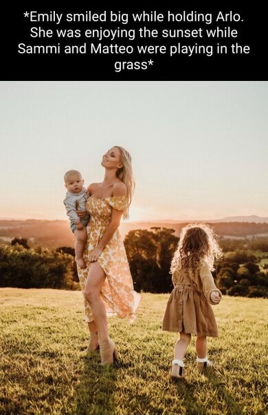 *Emily smiled big while holding Arlo. She was enjoying the sunset while ...