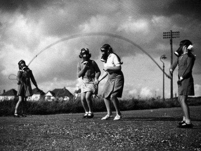 London children wear their gas masks as they skip in the park at their ...