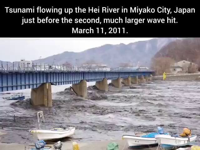 Tsunami flowing up the Hei River in Miyako City, Japan just before the ...